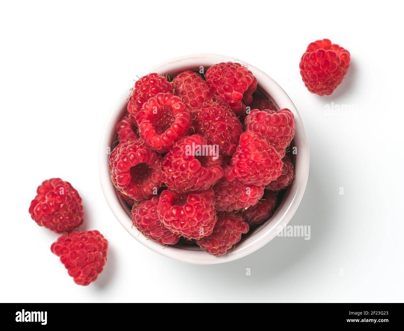 Raspberries in bowl isolated on white Stock Photo - Alamy