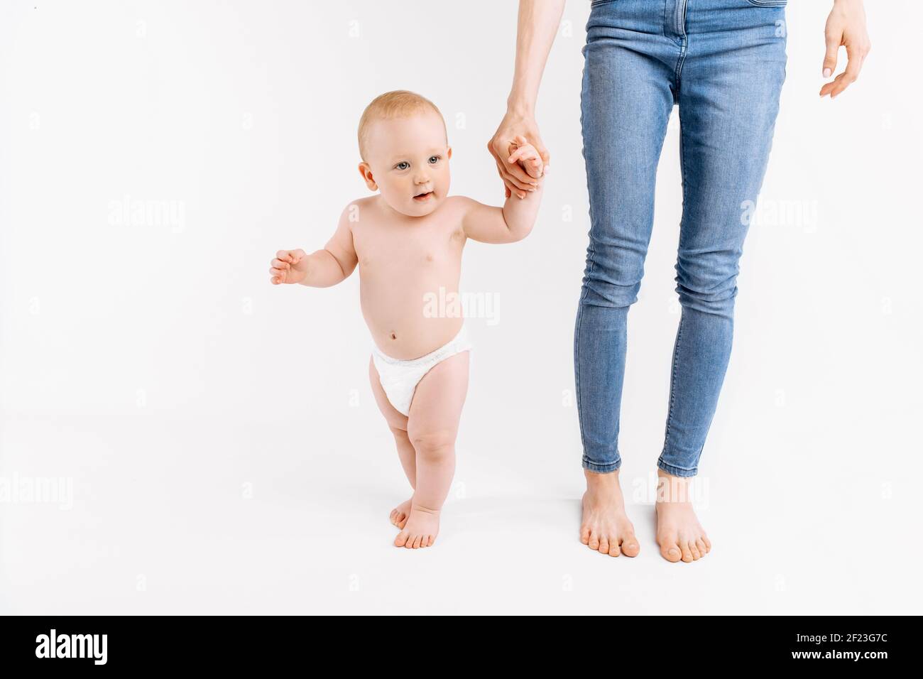 Little child taking the first steps, Happy little child learning to ...