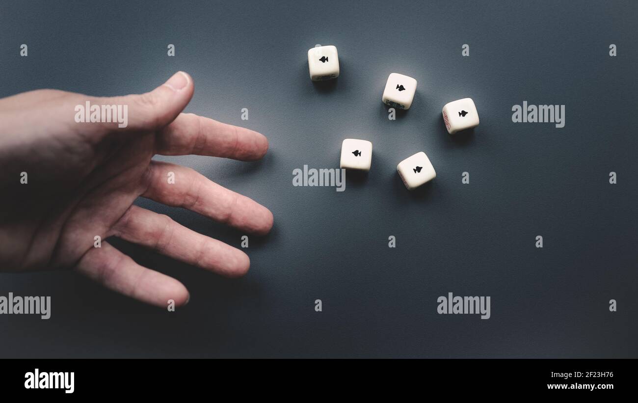 Throwing the dice on a dark grey background Stock Photo - Alamy