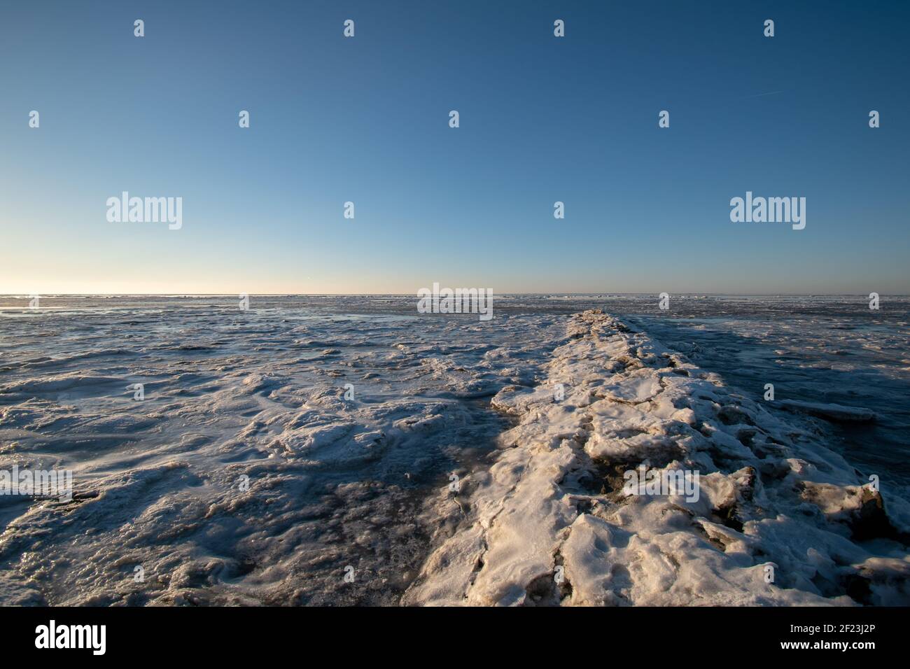 The frozen shore of a lake during sunset Stock Photo - Alamy