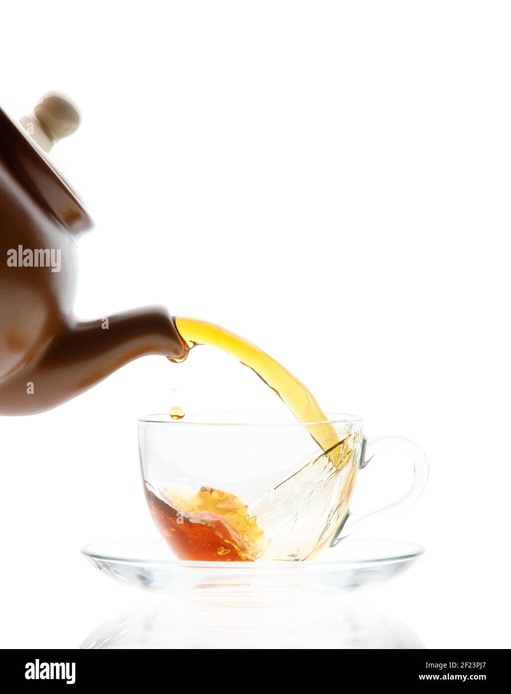 Pouring black tea into transparent cup from teapot Stock Photo - Alamy