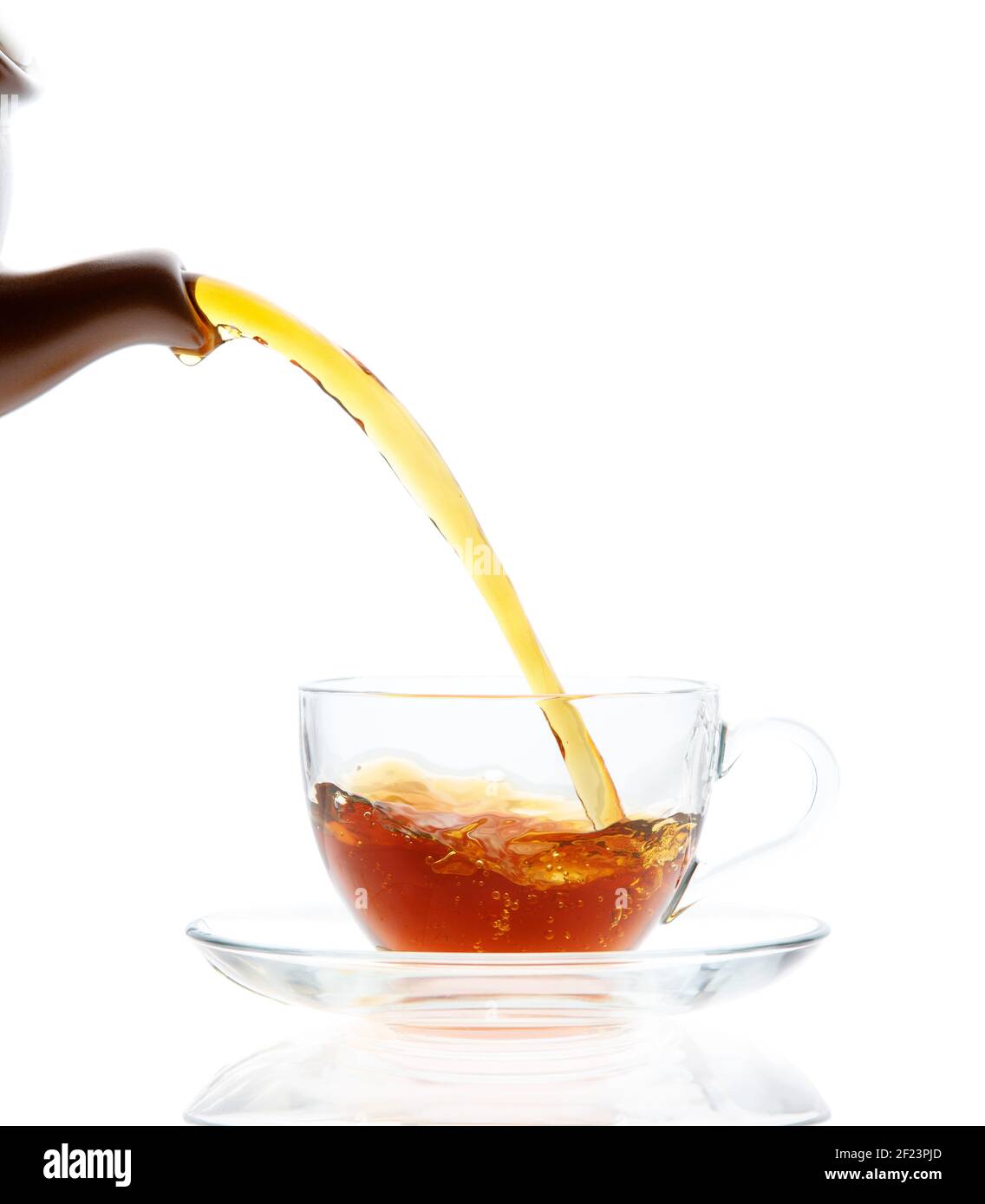 Pouring black tea into transparent cup from teapot Stock Photo - Alamy