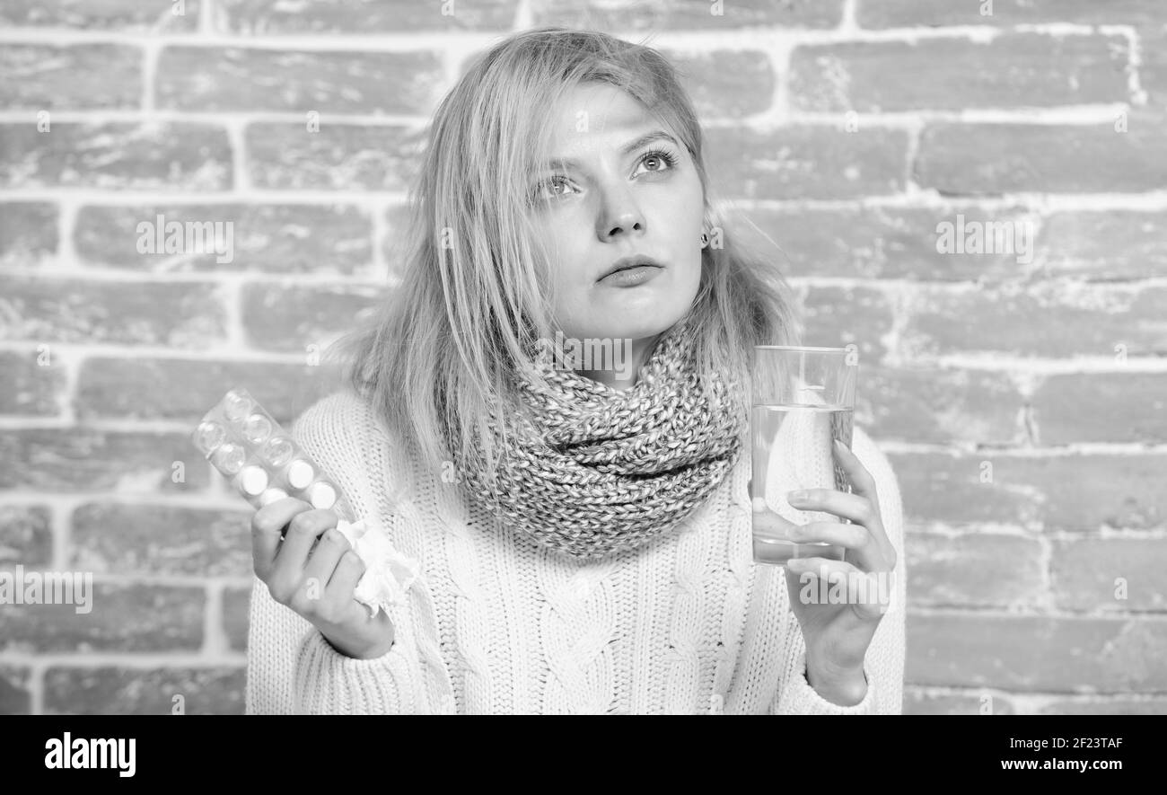 Searching for relief. Unhealthy woman holding pills and water glass ...