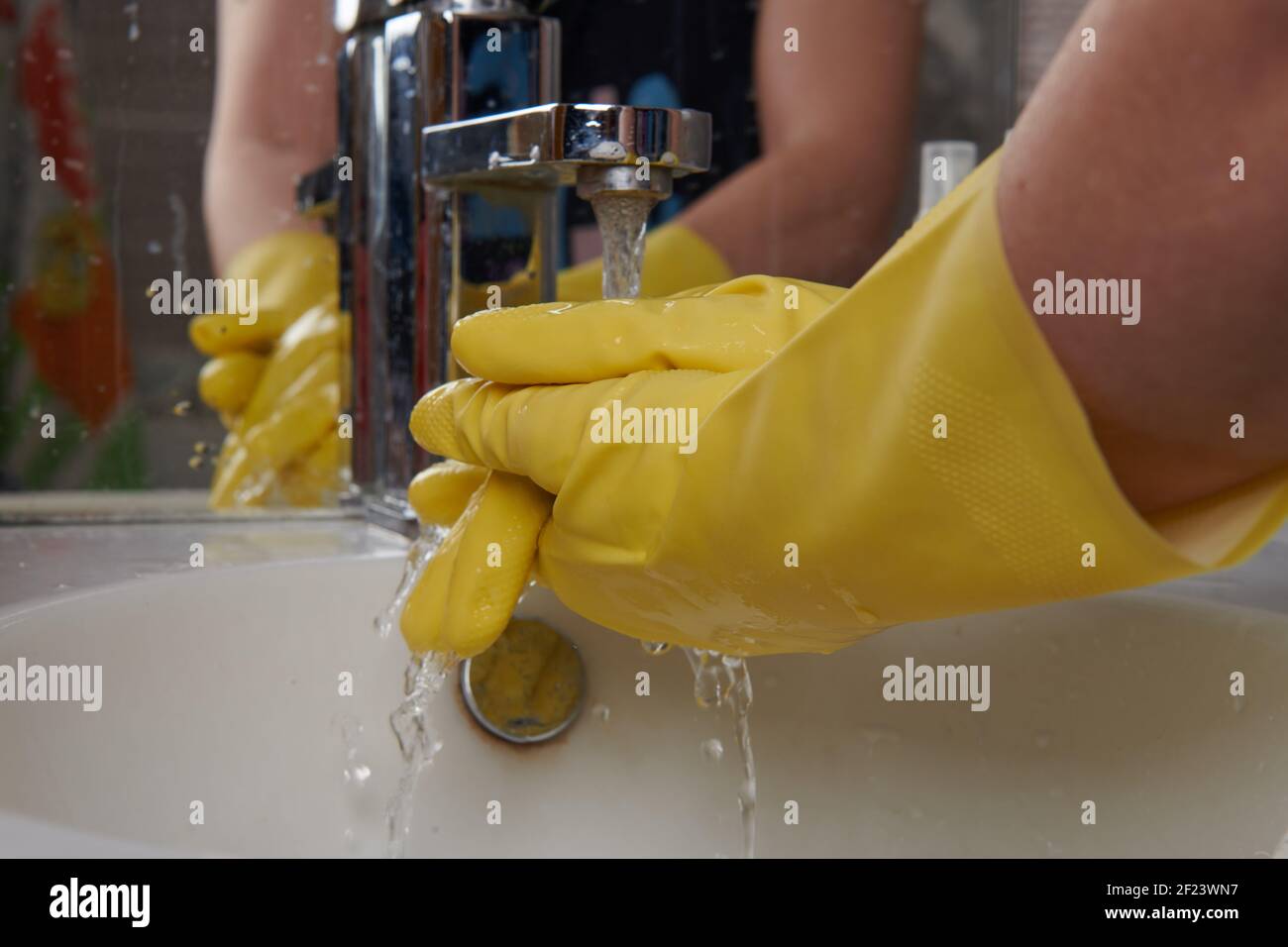 washing hands in yellow rubber gloves with water Stock Photo - Alamy