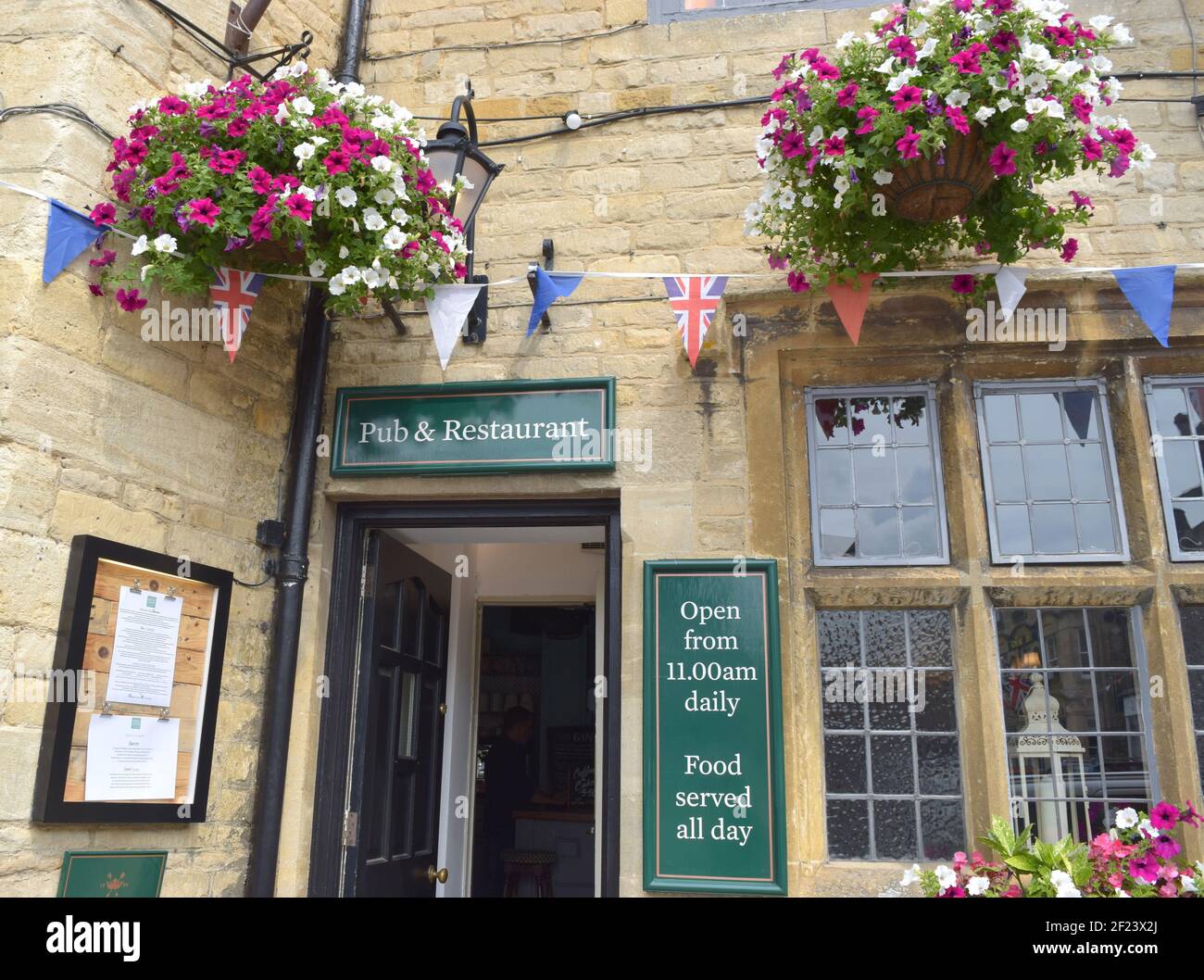 Old English pub decorated with flowers and colourful bunting Stock ...