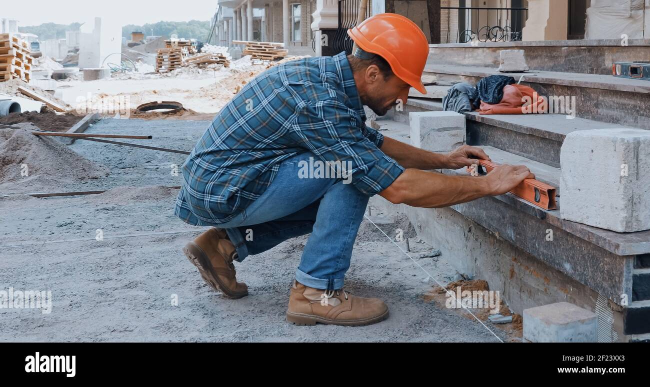 Builder measuring ground with building level on construction site Stock ...