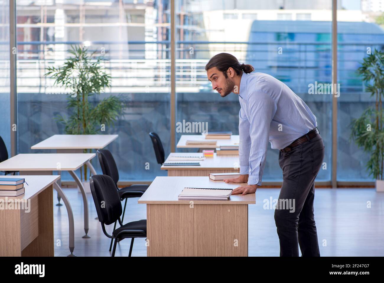 Young male teacher in the classroom Stock Photo - Alamy