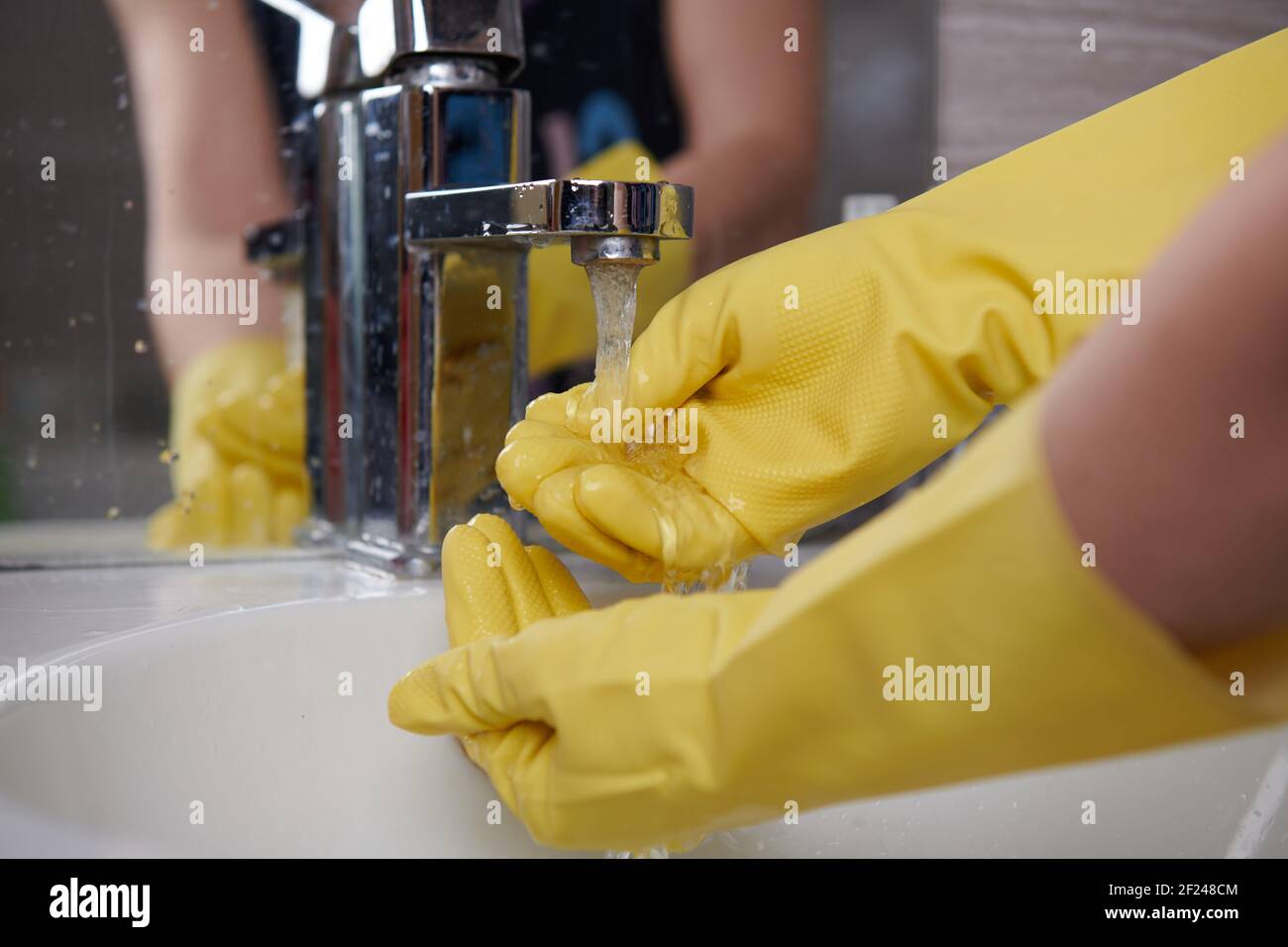 washing hands in yellow rubber gloves with water Stock Photo - Alamy