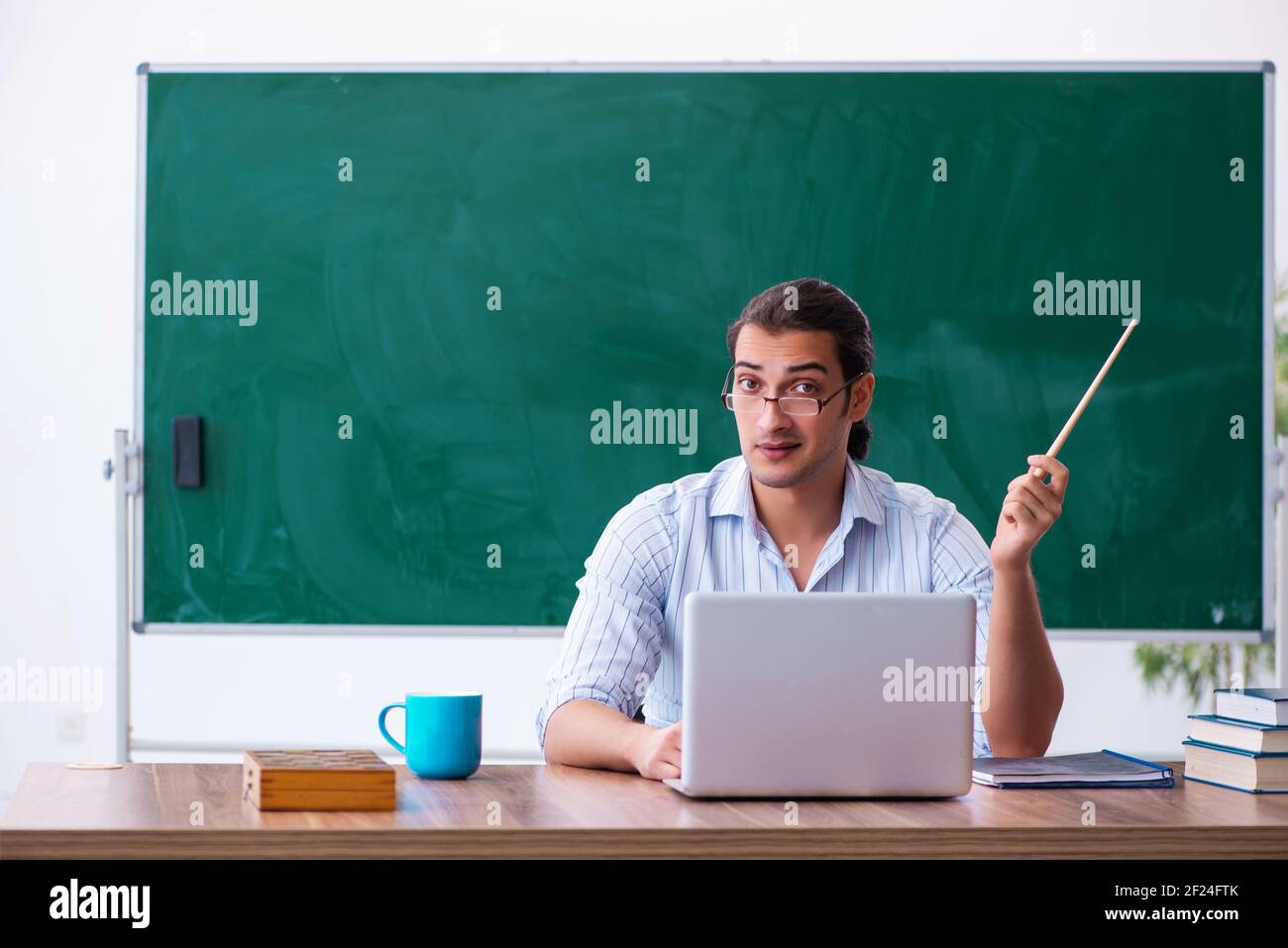 Young male teacher in tele-education concept in the classroom Stock ...