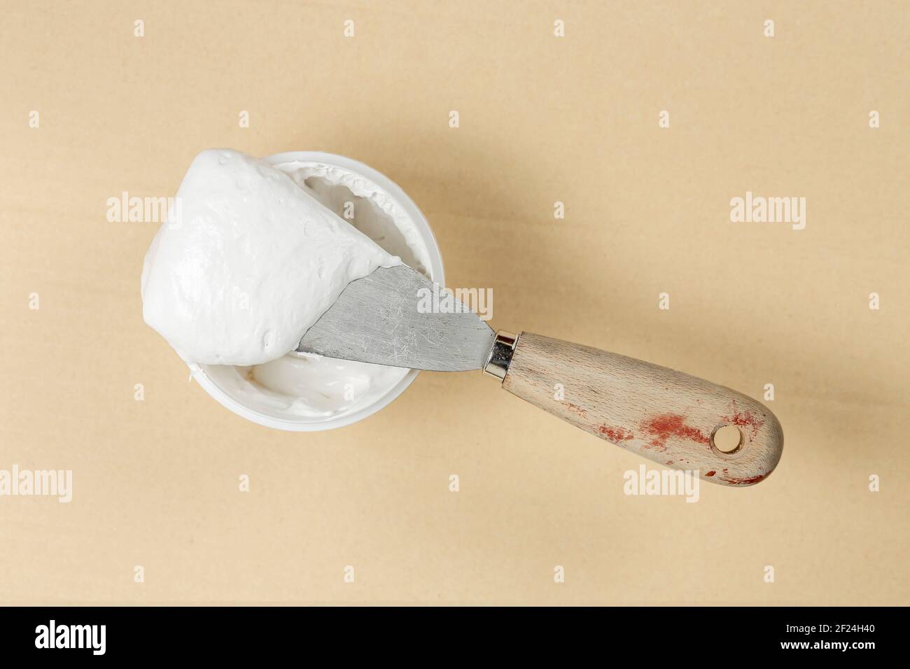 spatula on tub of white putty, top view on cardboard Stock Photo - Alamy