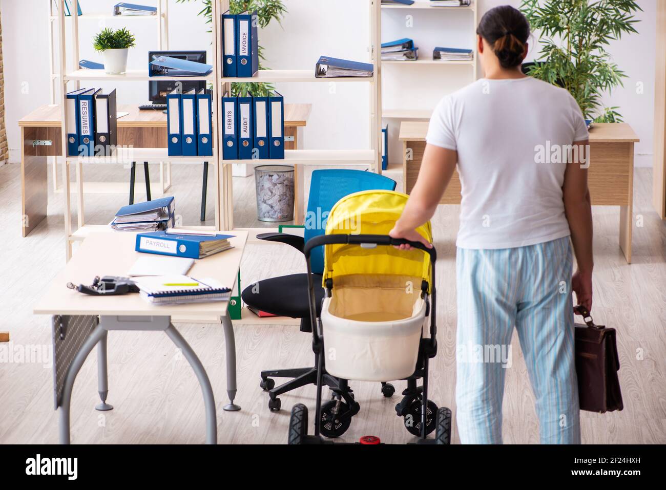 Young male employee looking after newborn at workplace Stock Photo - Alamy