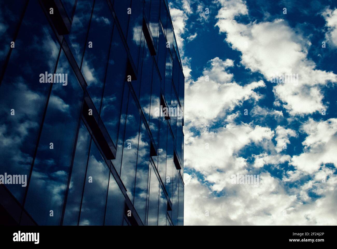 A low angle shot of a modern glass building under cloudy sky Stock ...