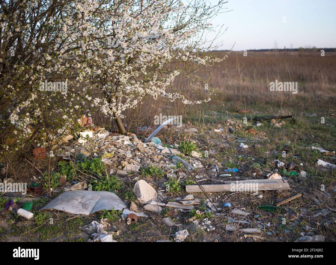 pile of rubbish from plastic bottles, construction waste on the grass ...
