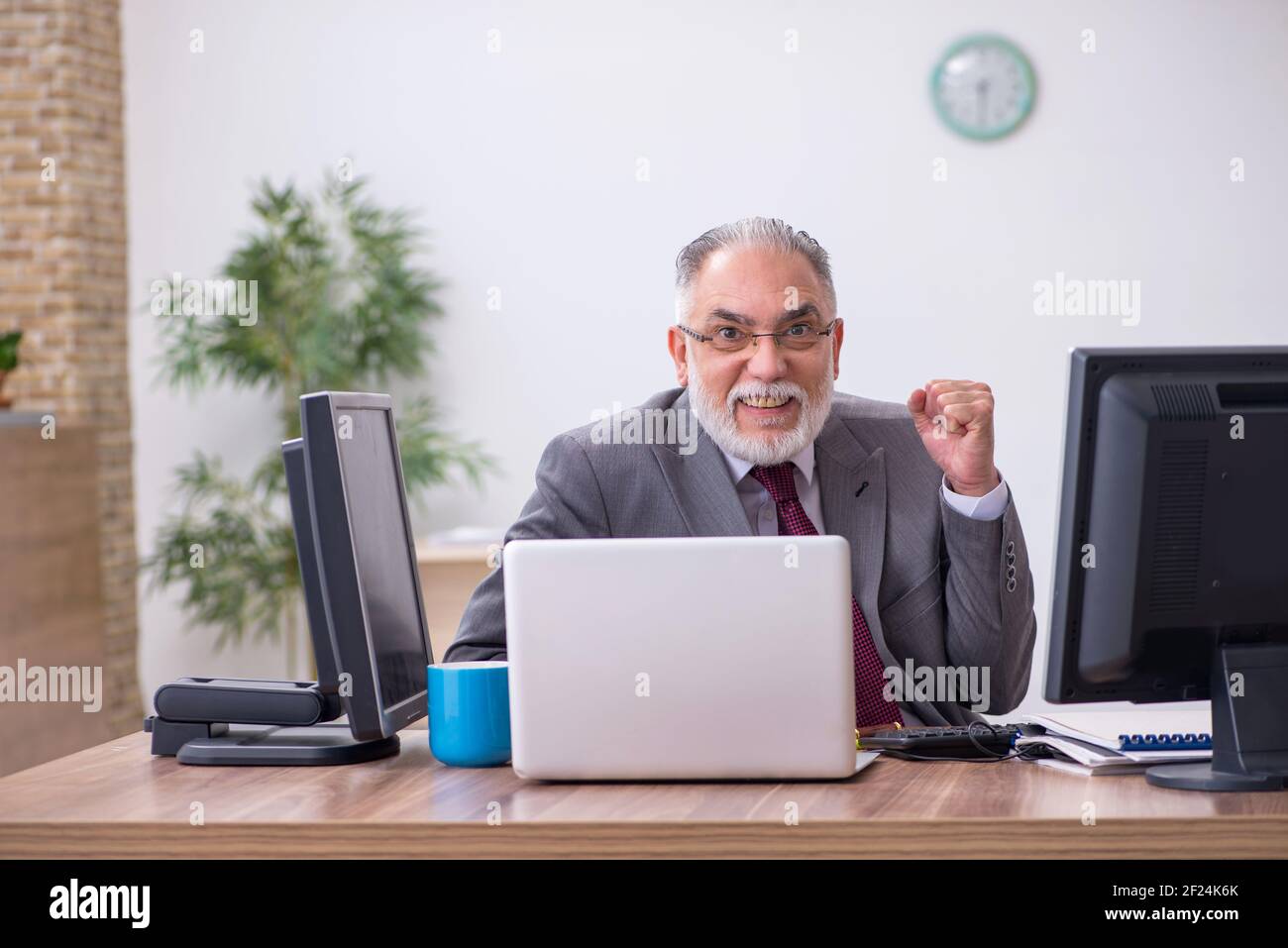 Old male boss sitting at desktop in the office Stock Photo - Alamy