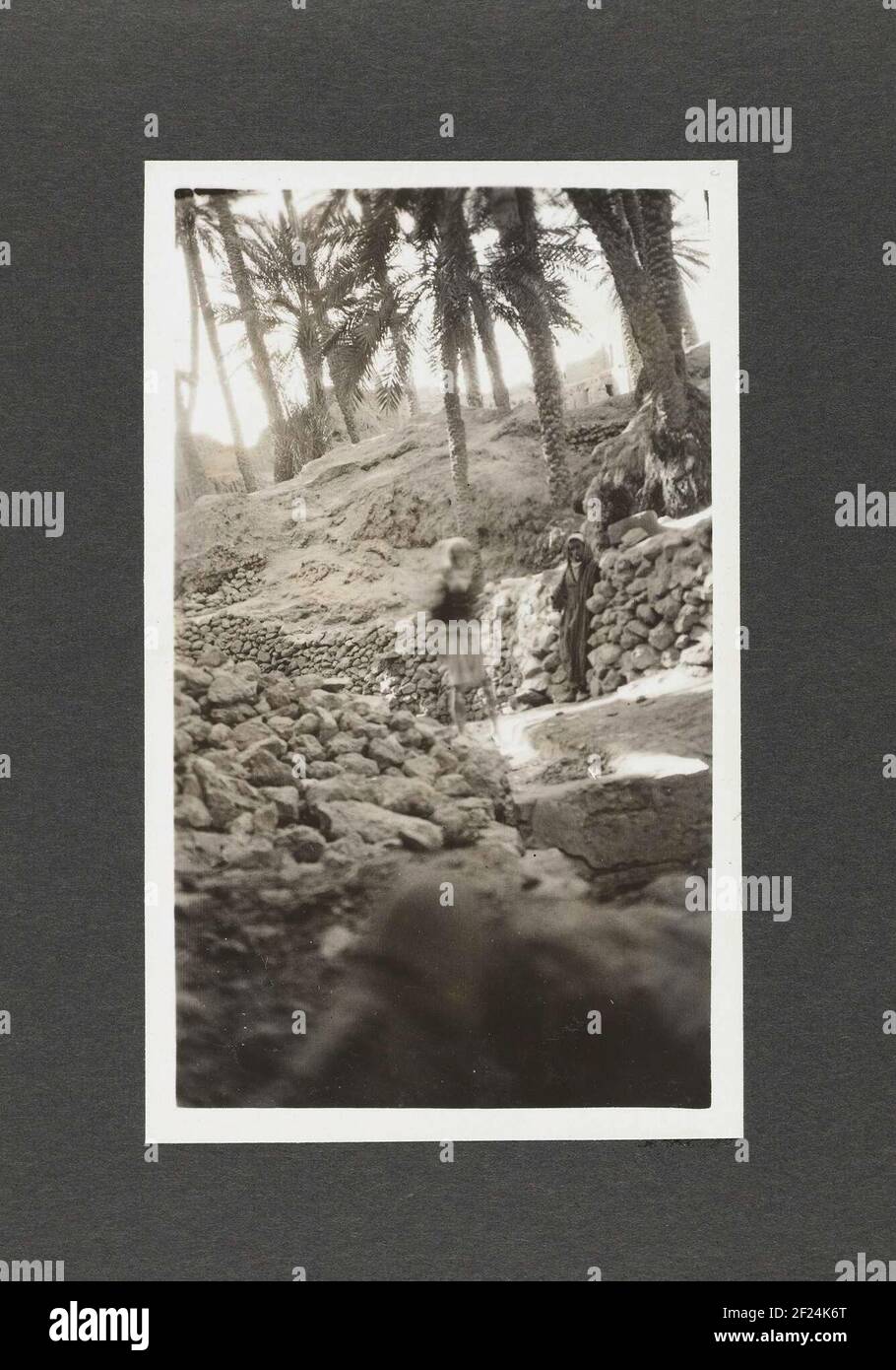 Two figures in a hilly landscape with palm trees in Oudaghir; Scene in ...