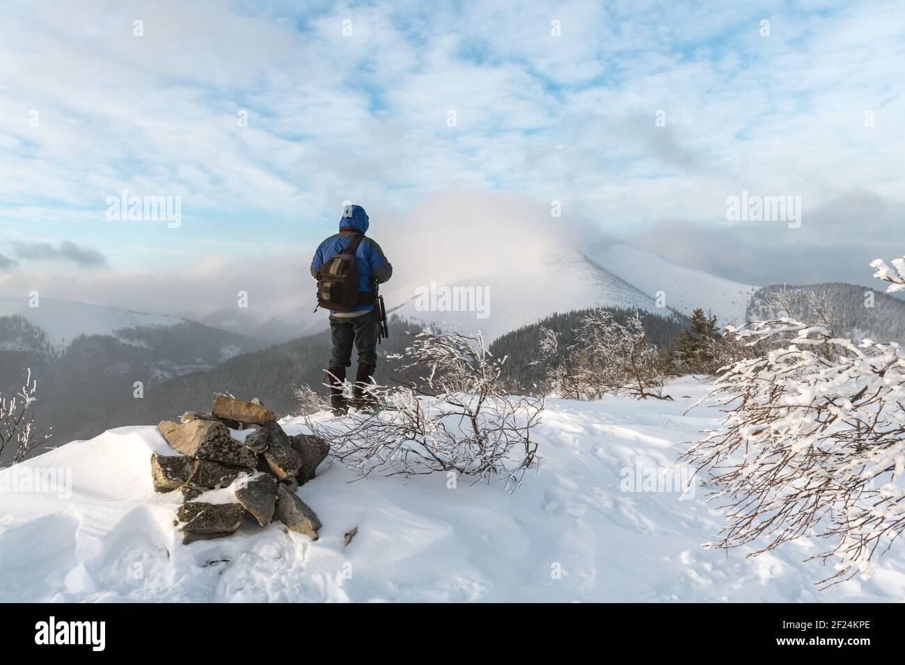Alone photographer in snowy hills in hight winter mountains in sunrise ...