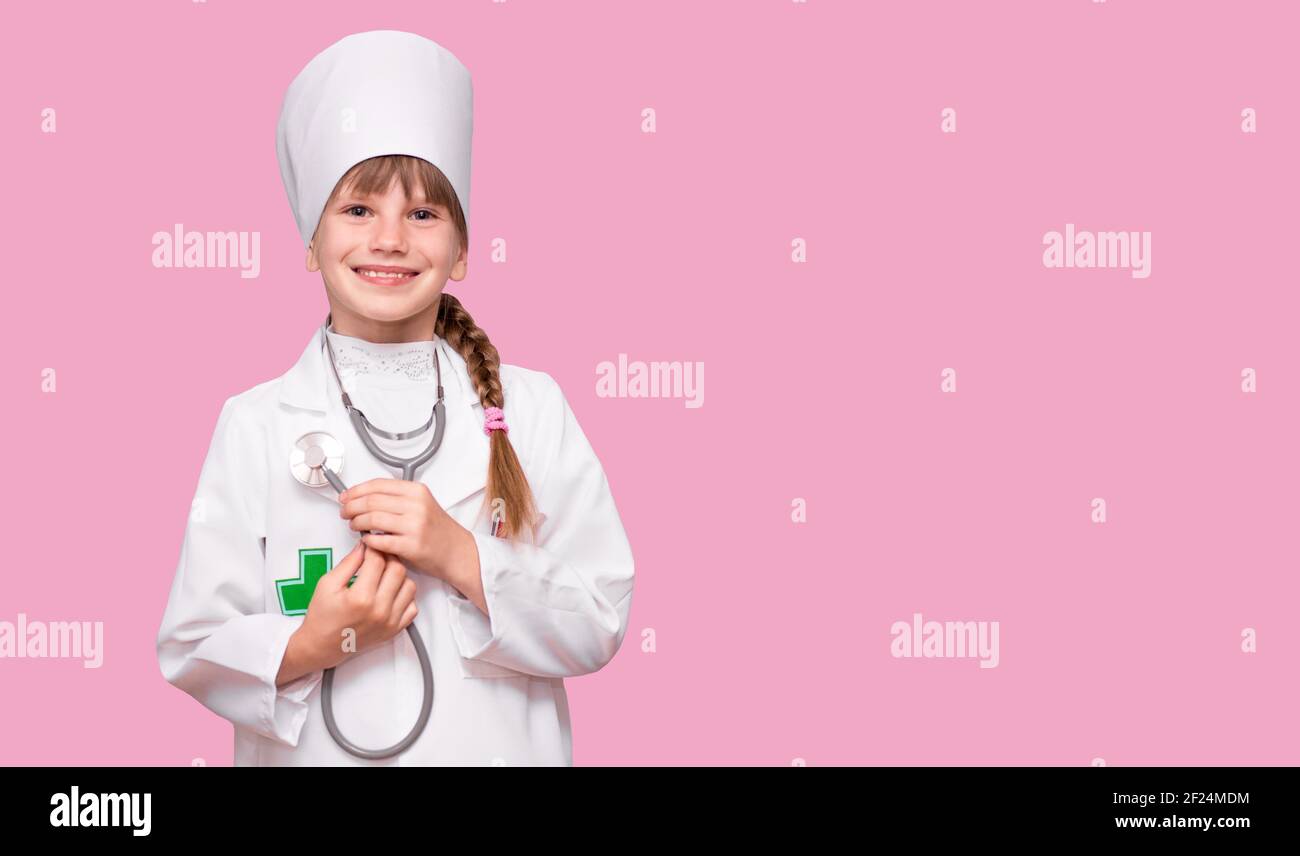Little, cute girl future doctor dressed white medical apron with ...