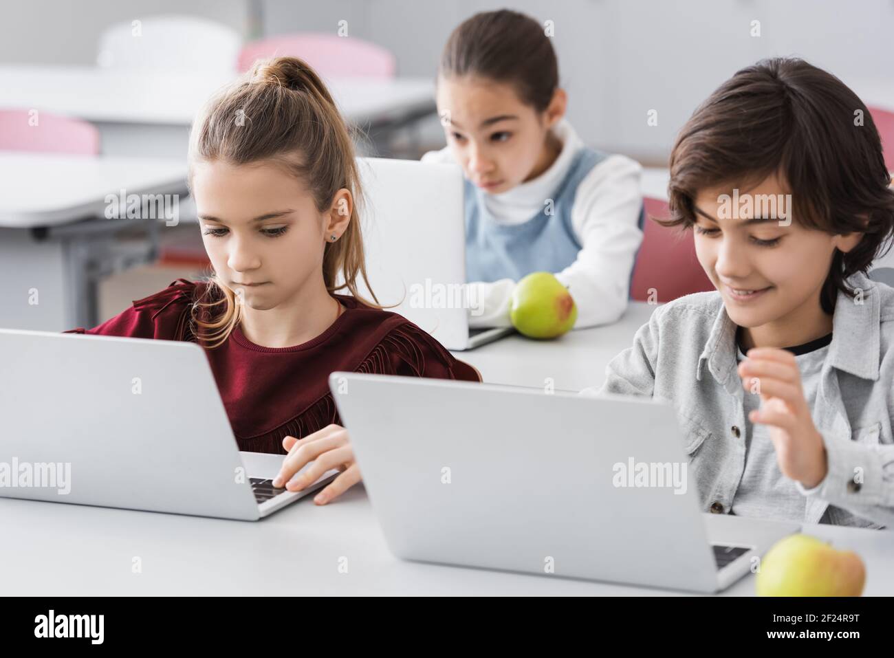 concentrated kids using laptop during lesson in school on blurred ...