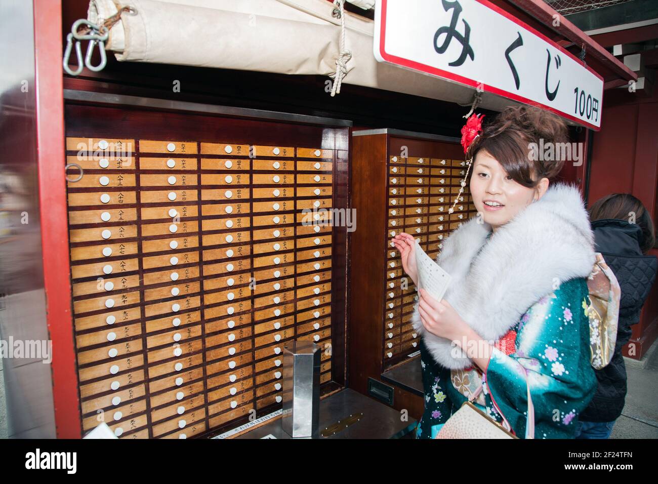 Pretty Japanese lady in kimono checking omikuji fortune telling on Coming of Age Day (Seijin no ...