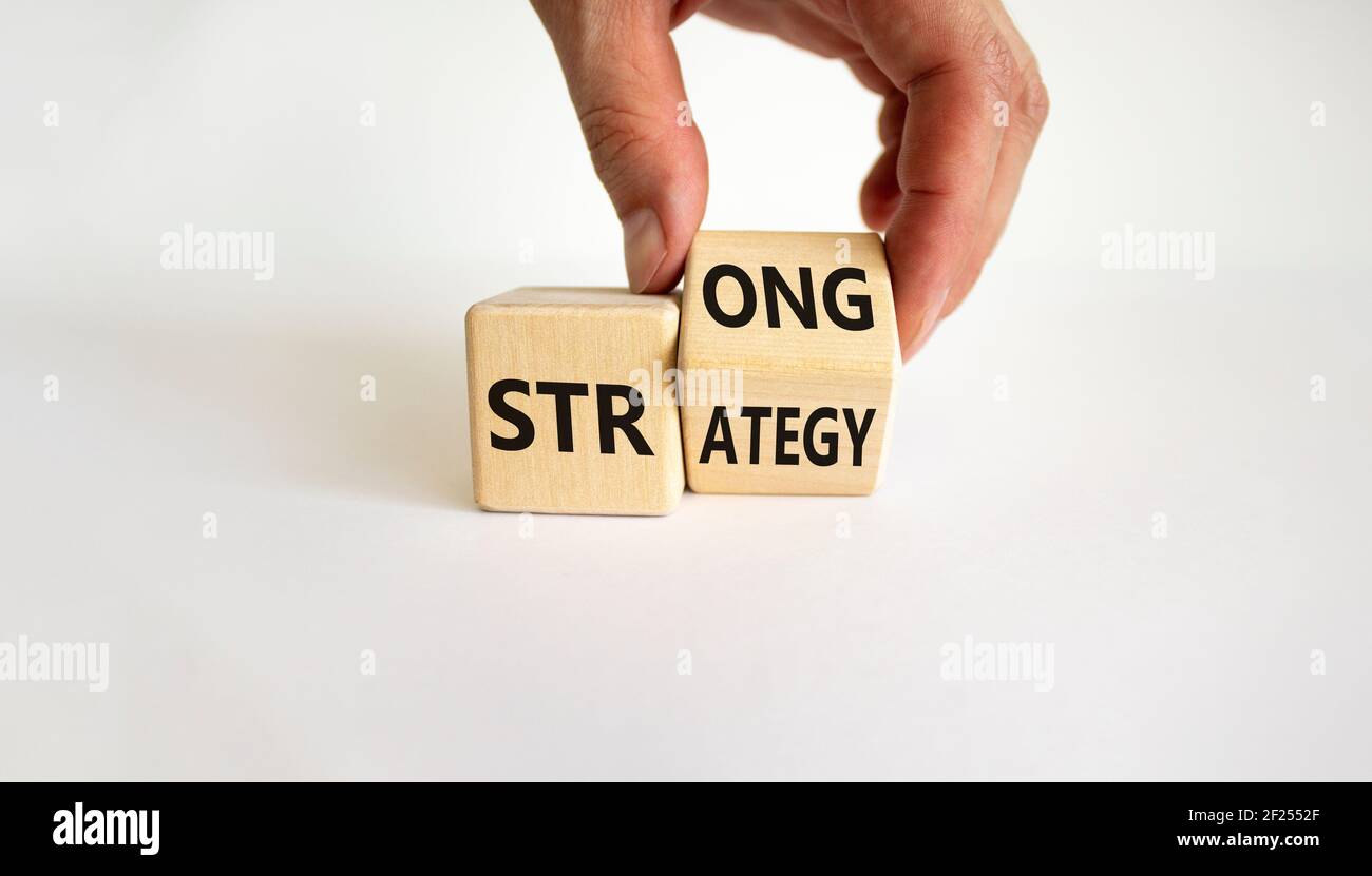 Strong strategy symbol. Businessman turns a wooden cube with words ...