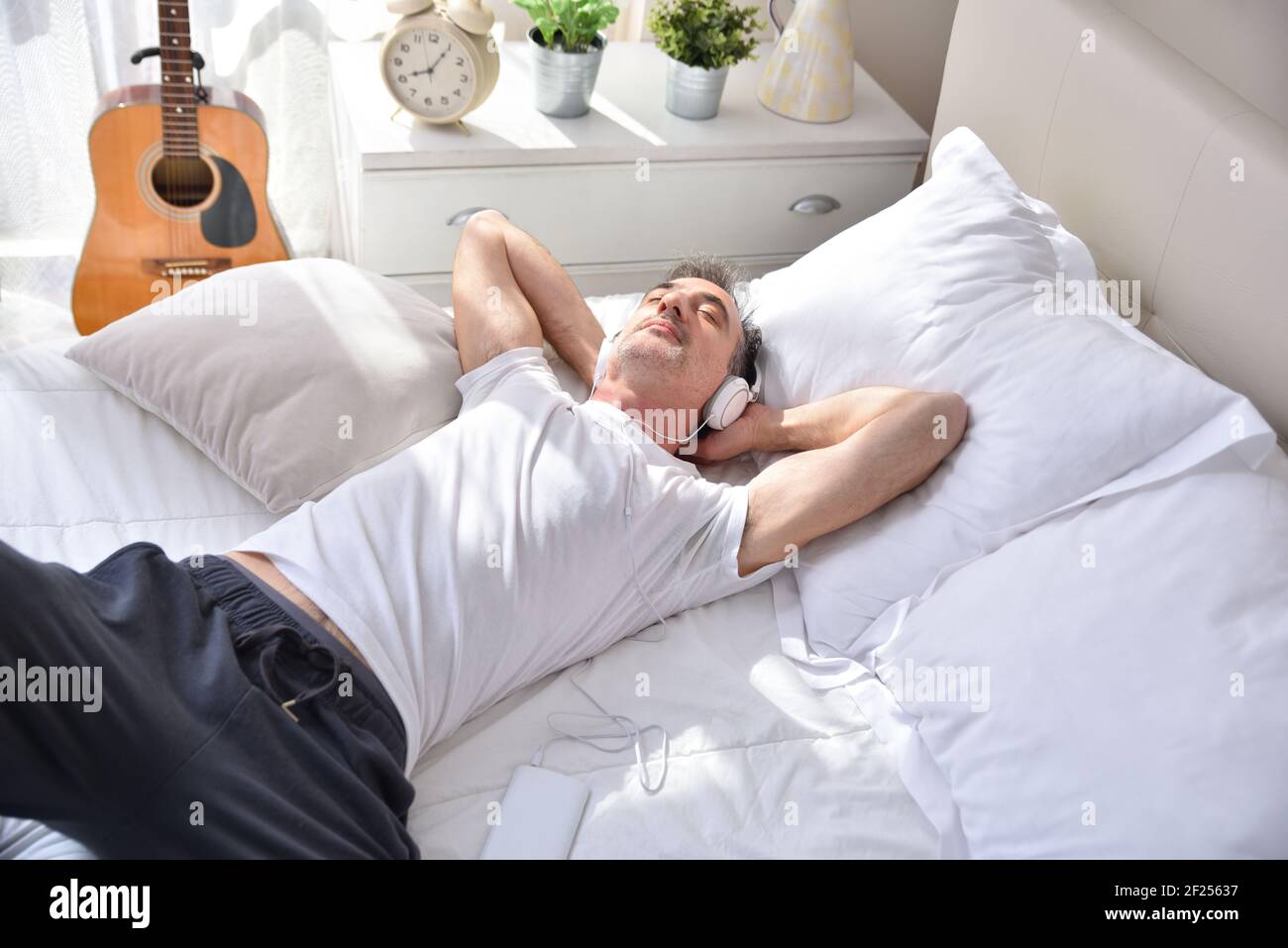 Happy And Relaxed Adult Man With Closed Eyes Dressed In Pajamas