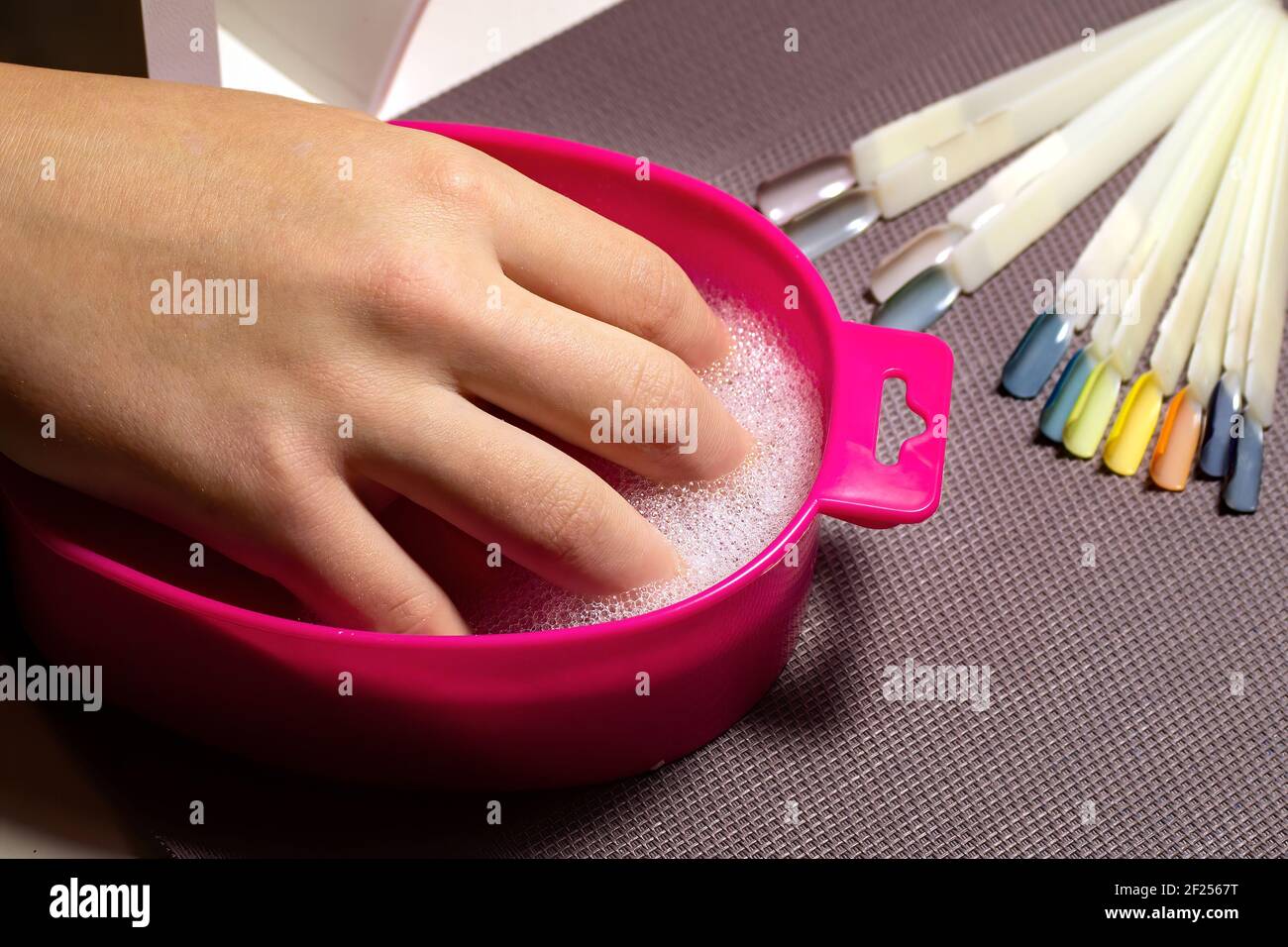 Soaking and steaming the skin of the hands with soapy water in a pink ...