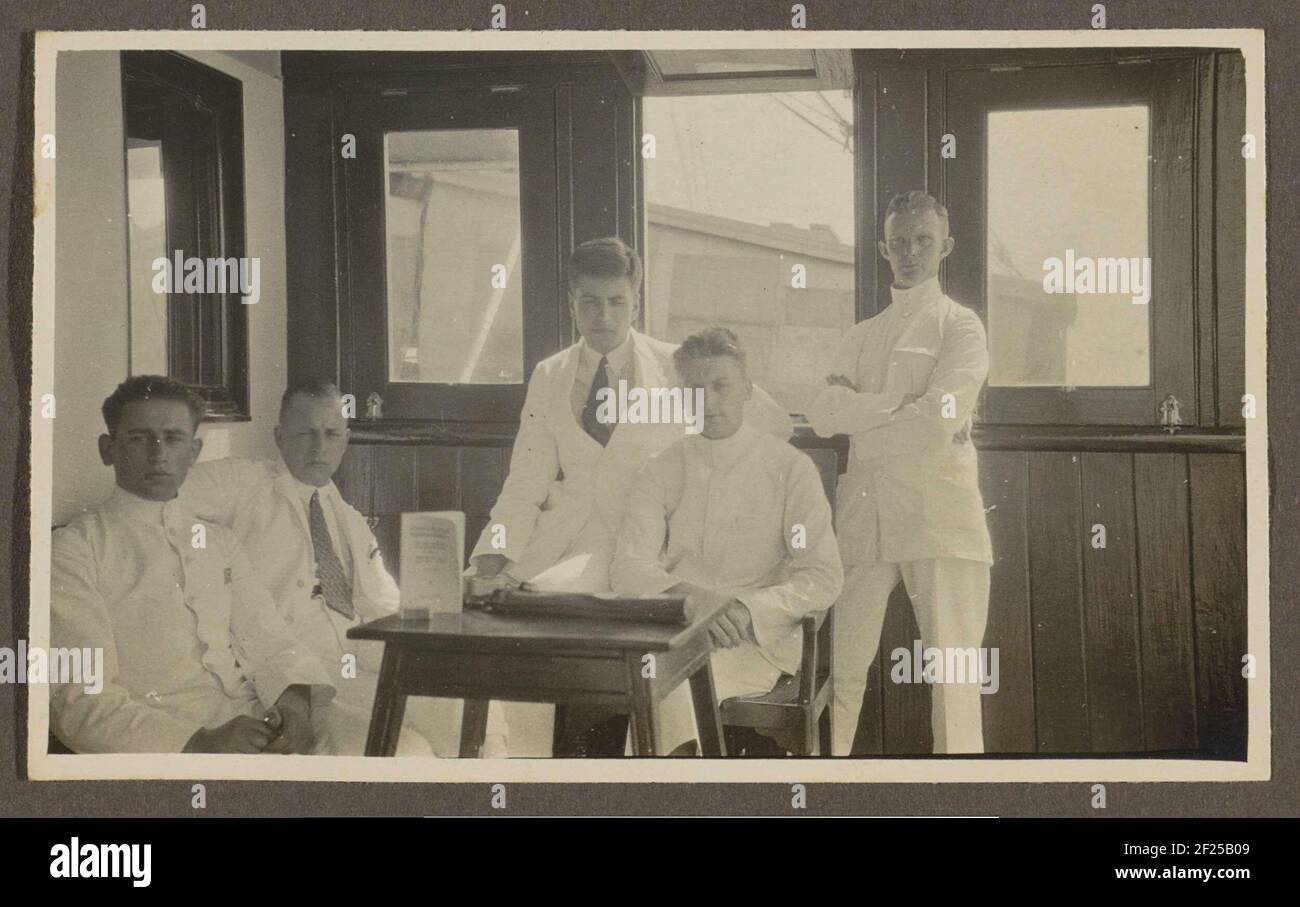 Five men in tropical clothing sitting around a table.part or family ...