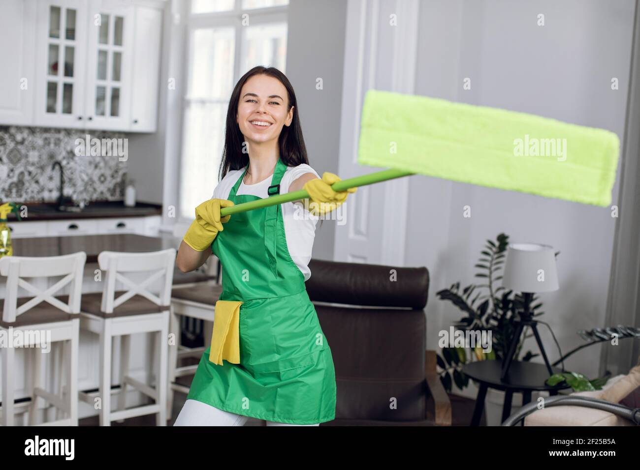 Female housekeeper playing with mop during cleaning process Stock Photo ...