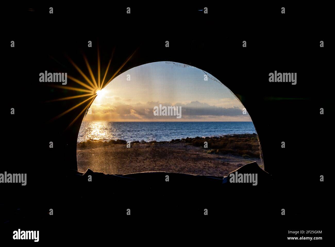 view of a beautiful sunrise over the ocean through the window of a pop ...
