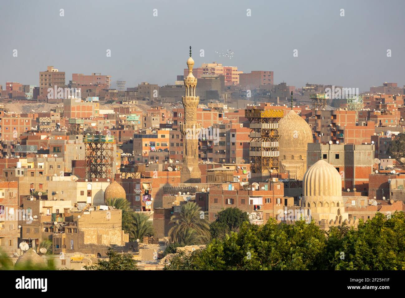 Cairo cityscape showing mosques and minarets bathed in golden light, as ...