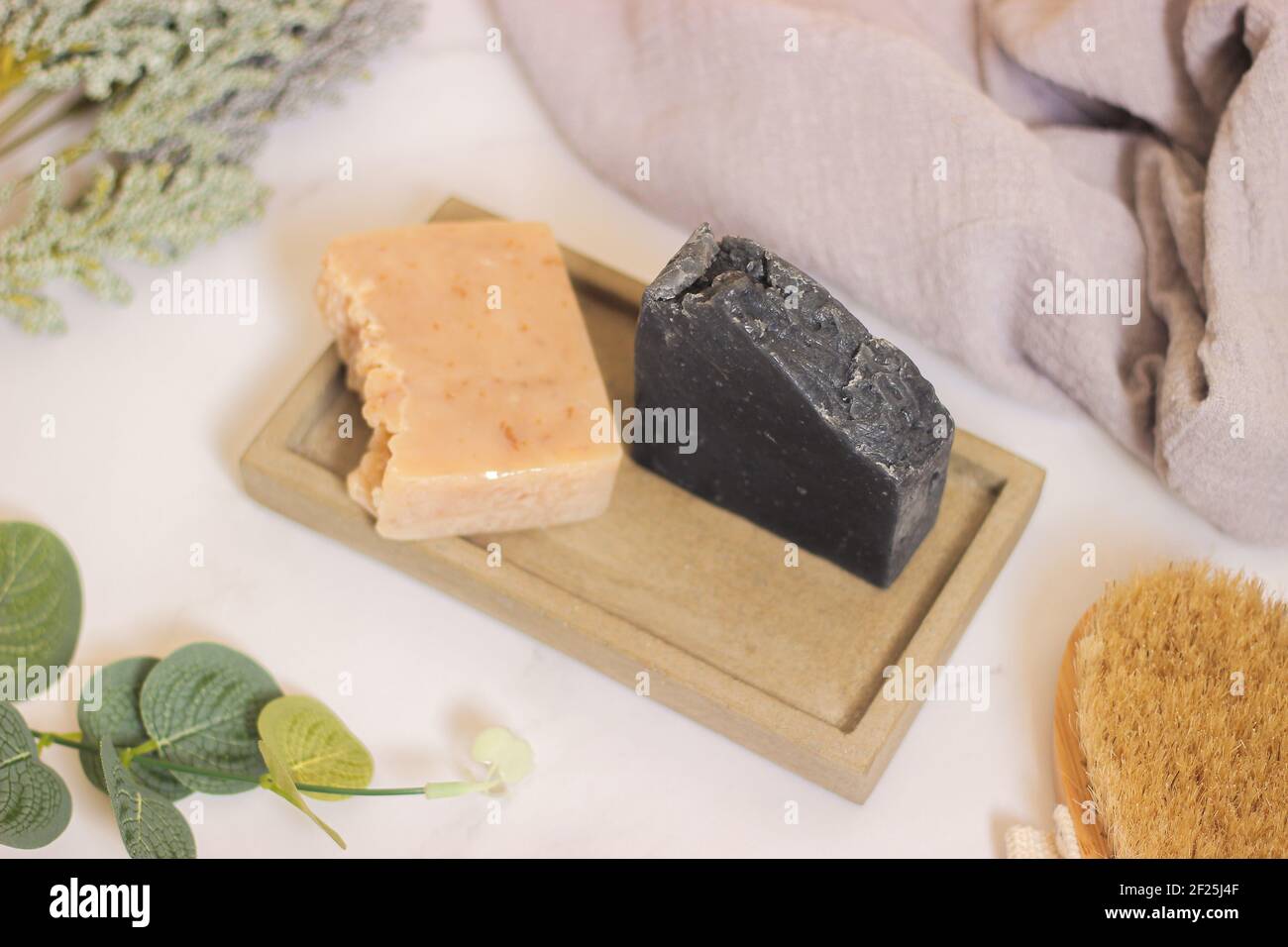 Two soaps and other beauty care products on a white table in the ...