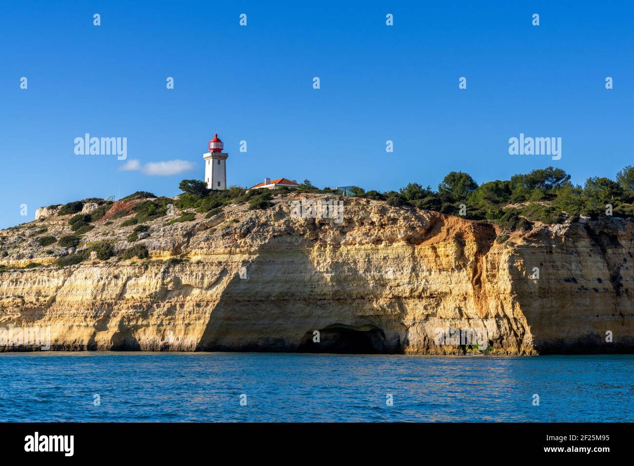 A view of the Alfanzina lighthouse on the beautiful Algarve coast of ...