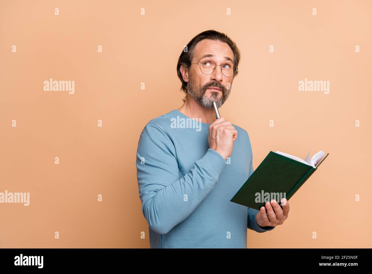 Photo of pensive smart man hold pen notepad look empty space wear specs ...