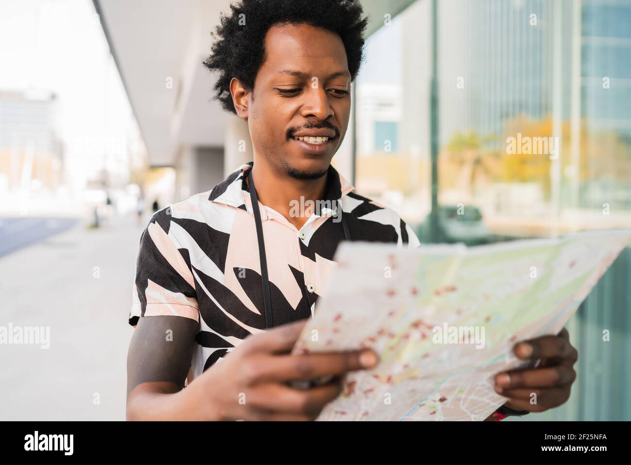 Tourist man looking for directions on map Stock Photo - Alamy