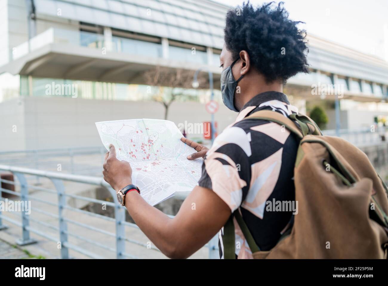 Tourist man looking for directions on map Stock Photo - Alamy