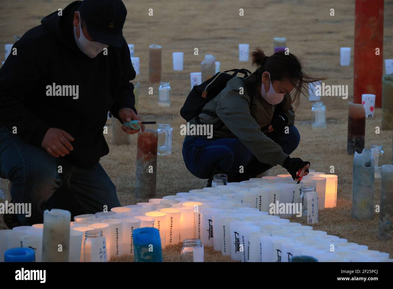 Futaba, Japan. 10th Mar, 2021. Volunteers light candles which form ...