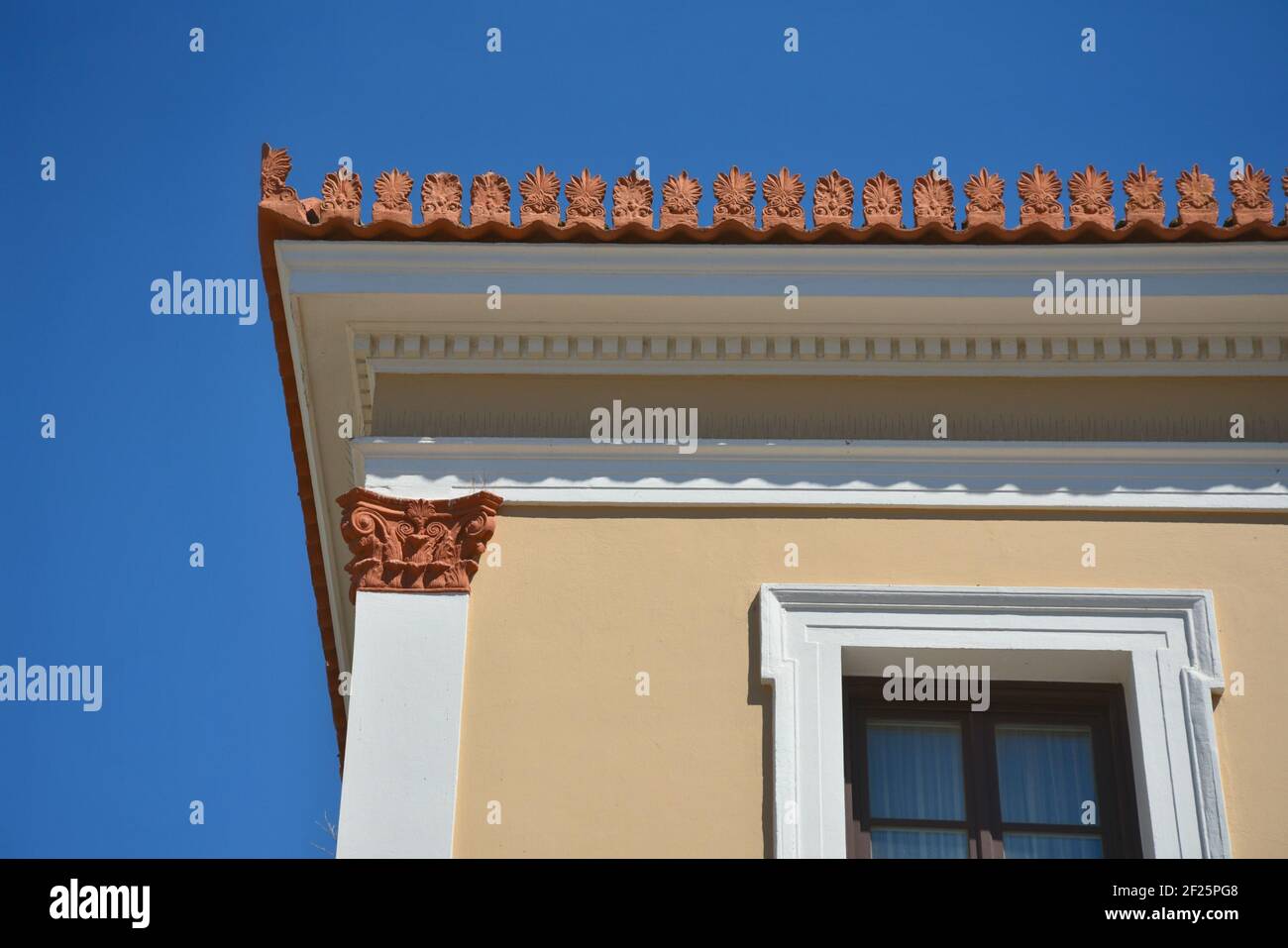 Neoclassical building partial facade view with red clay Antefix ...