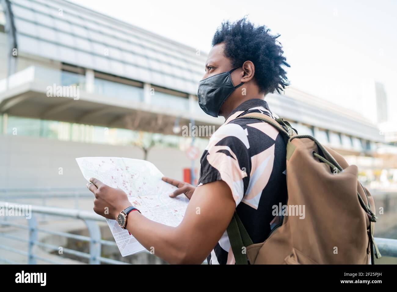 Tourist man looking for directions on map Stock Photo - Alamy