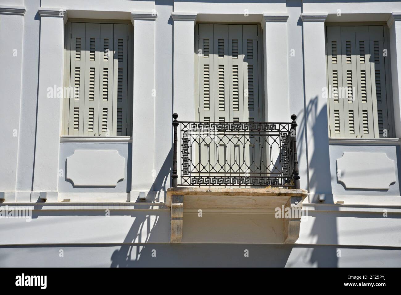 Neoclassical house facade with pearl grey window shutters and a hand ...