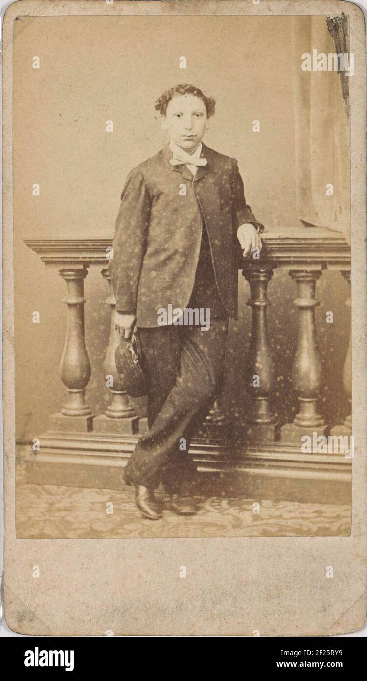 Portrait of a standing young man with a cap in hand Stock Photo - Alamy