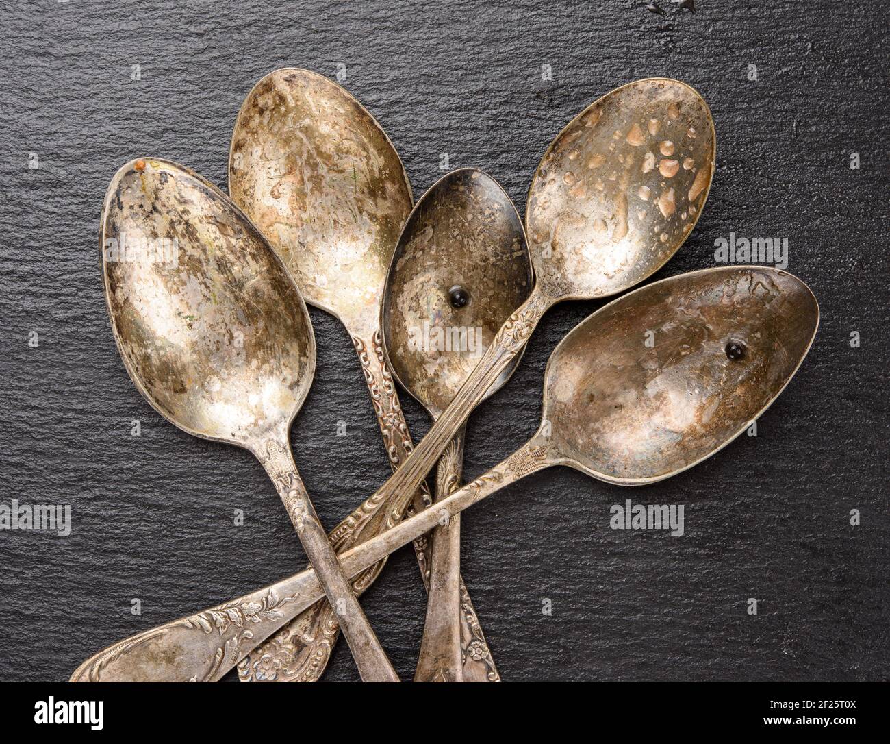 Vintage metal empty spoons on black graphite background Stock Photo - Alamy