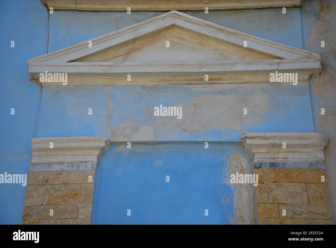 Neoclassical style white plaster pediment facade on a faded light blue ...