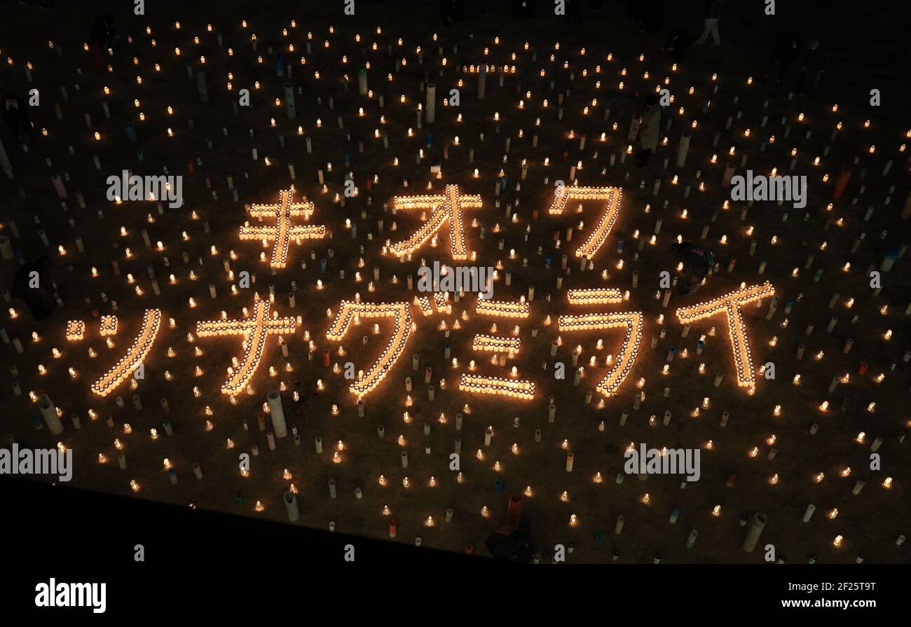 Futaba, Japan. 10th Mar, 2021. Volunteers light candles which form ...