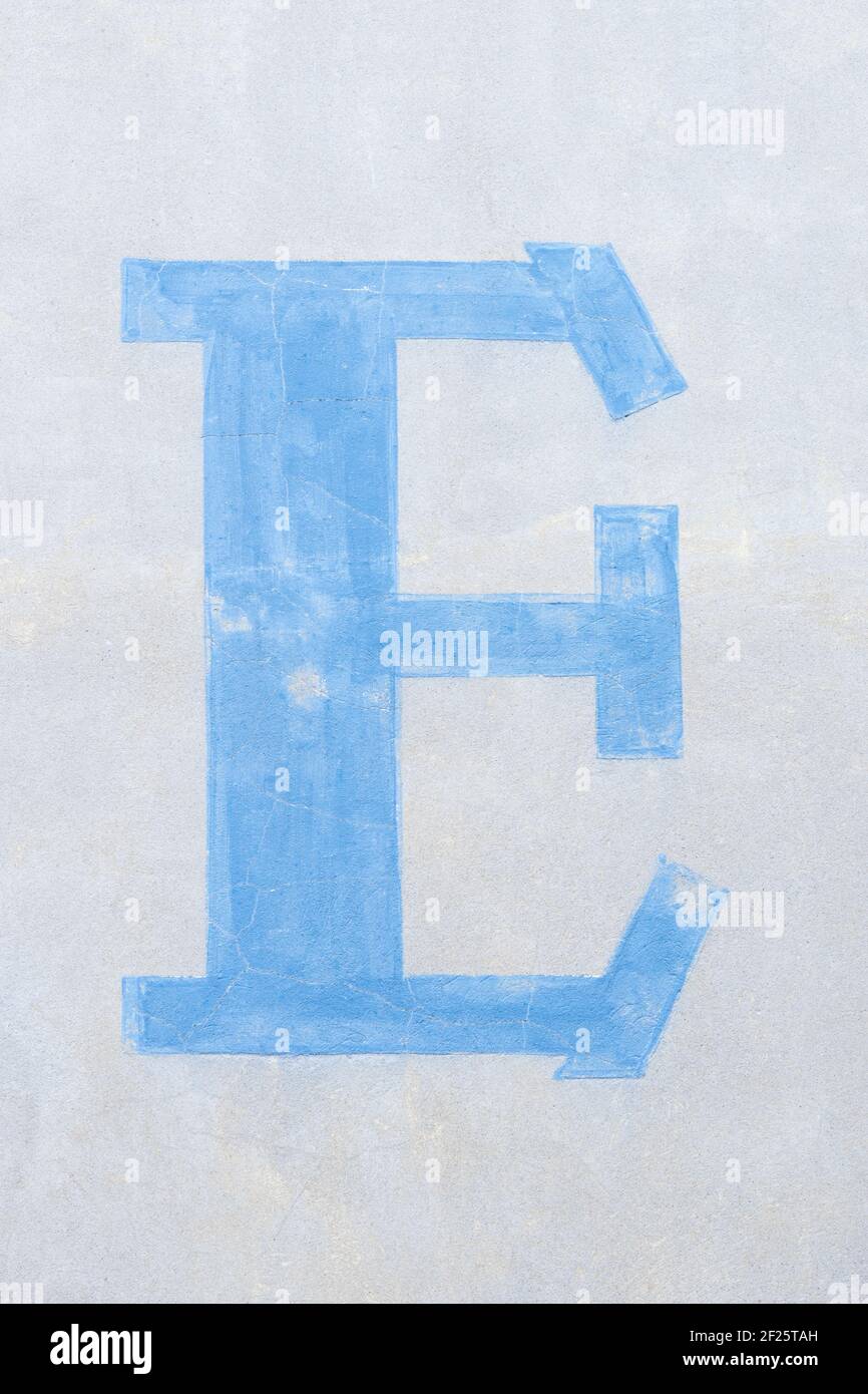Light blue letter E in serif font on a light grey wall Stock Photo - Alamy