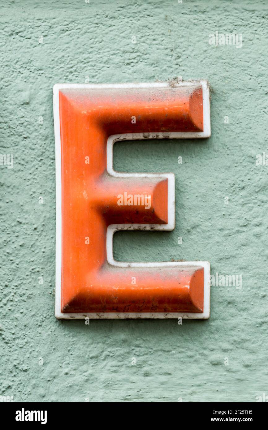 Orange letter E with white outline against light green background Stock ...