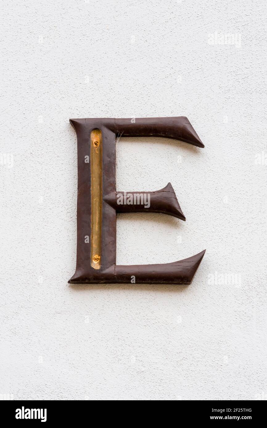 Brown wooden letter E with golden decorative lines Stock Photo - Alamy