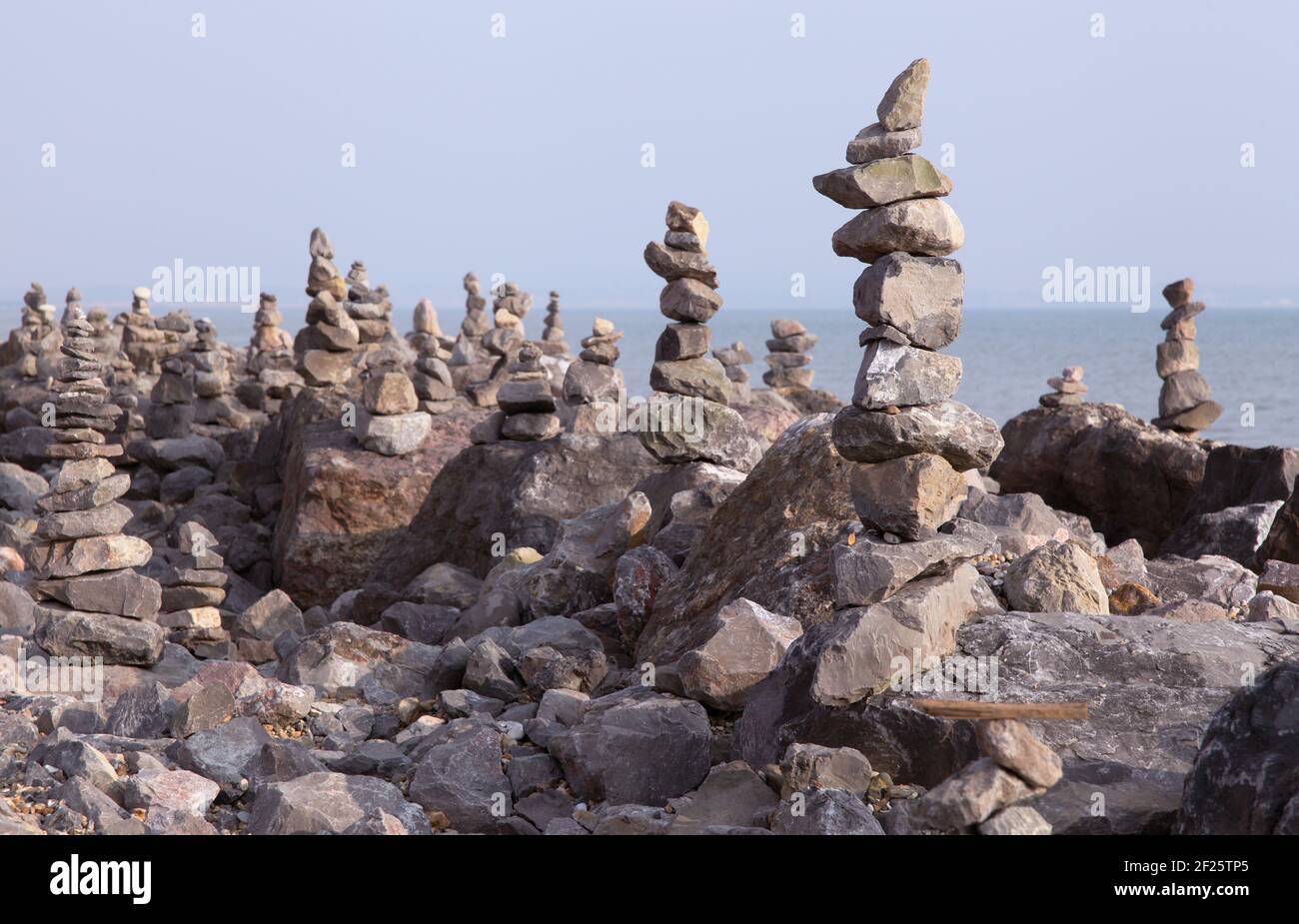 Beach shoreline with hundreds of balancing stones or balanced rocks ...