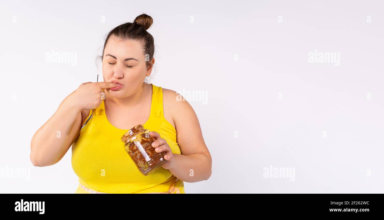 Banner,long format. An overweight woman happily eats chocolate paste ...