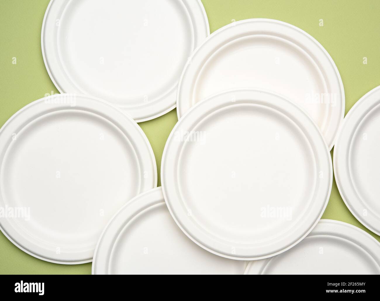 White paper disposable plates on a green background, top view Stock ...