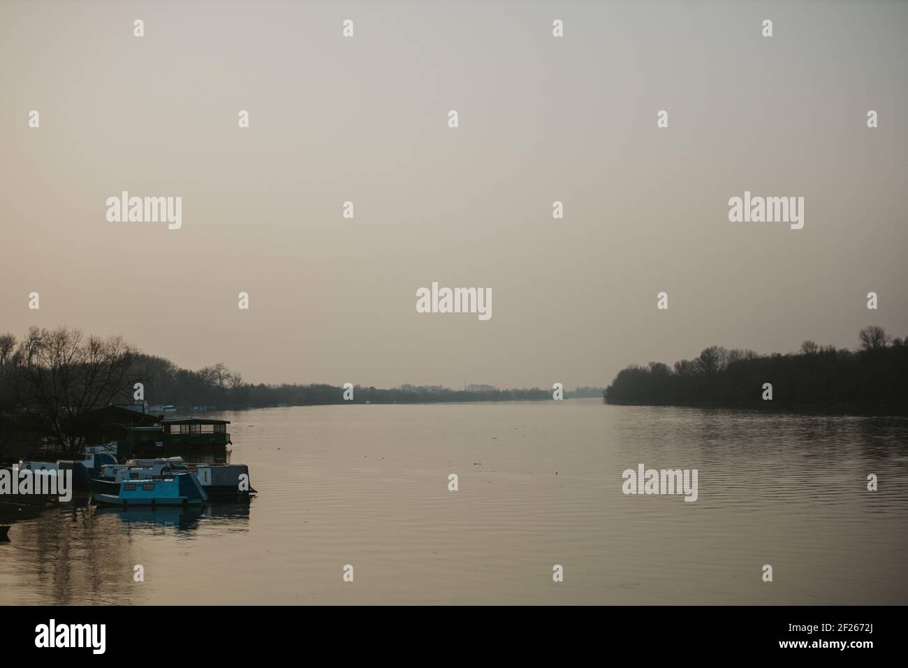 A cloudy riverfront view with the white and blue boats Stock Photo - Alamy